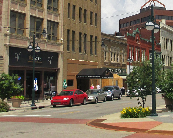 Historic charm meets modern life at this downtown Moline corner, where century-old architecture frames bustling street life beneath stylish blue awnings.