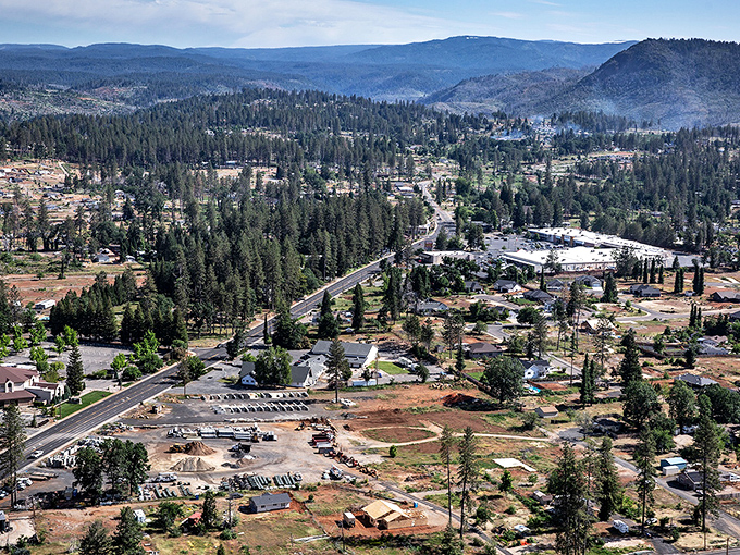 An aerial view that tells the story of resilience. Paradise stretches across the Sierra foothills like nature's quilt, pine trees standing guard over rebuilding neighborhoods.