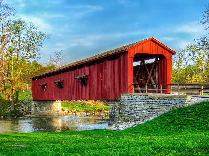 The crimson sentinel stands proudly against Indiana's blue sky, its weathered boards telling stories of horse-drawn wagons and simpler times.
