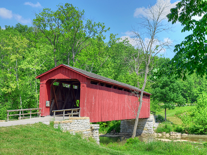 The crimson sentinel stands proudly against Indiana's blue sky, its weathered boards telling stories of horse-drawn wagons and simpler times.