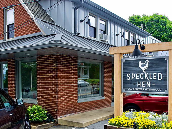 The brick exterior of Speckled Hen welcomes you like an old friend, with its cheerful yellow flowers and rustic wooden sign promising delicious possibilities within.