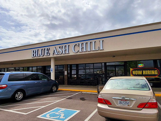 The blue lettering of Blue Ash Chili stands out against the strip mall backdrop like a neon promise of comfort food nirvana ahead.