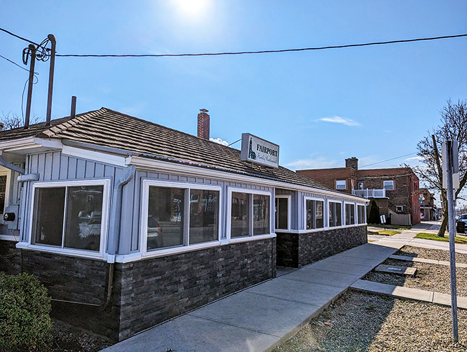 The unassuming exterior of Fairport Family Restaurant, where culinary magic happens behind that modest striped awning and simple sign.