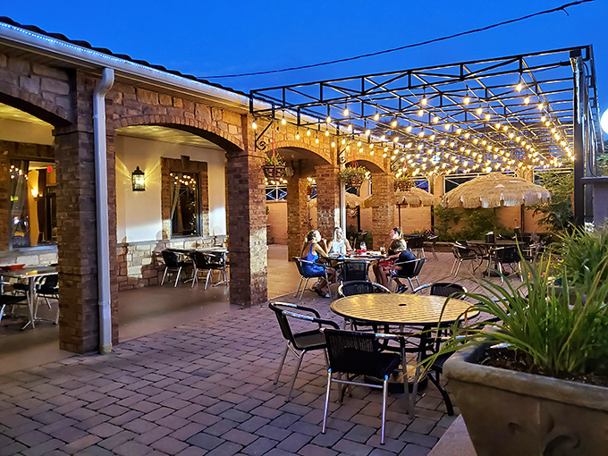 Mediterranean charm meets Pennsylvania practicality at JoJo's exterior, where those red umbrellas beckon like old friends promising good times and better pizza.