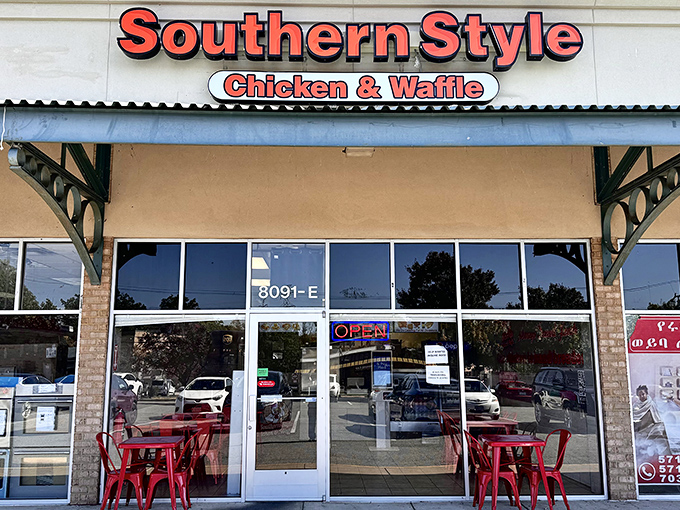 The bright red signage of Southern Style Chicken & Waffle beckons like a lighthouse to hungry souls navigating the sea of strip mall sameness.
