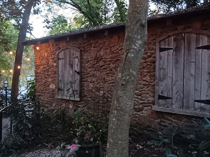 A stone cottage nestled among towering trees isn't just fairy tale scenery—it's your first clue that The Peddler isn't your average strip mall steakhouse.