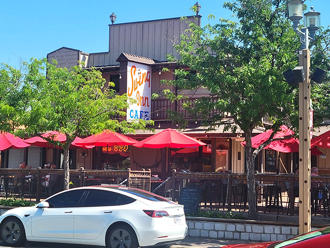 The iconic Swing Inn beckons with its cheerful red umbrellas and rustic charm, a Temecula treasure hiding in plain sight.