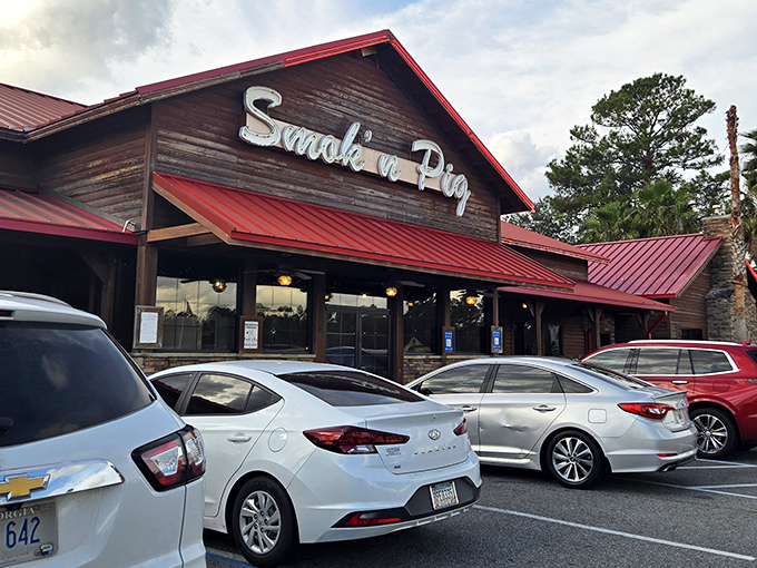 The rustic wooden exterior with its signature red roof stands like a BBQ beacon. Come hungry, leave happy—and possibly in need of elastic waistbands.