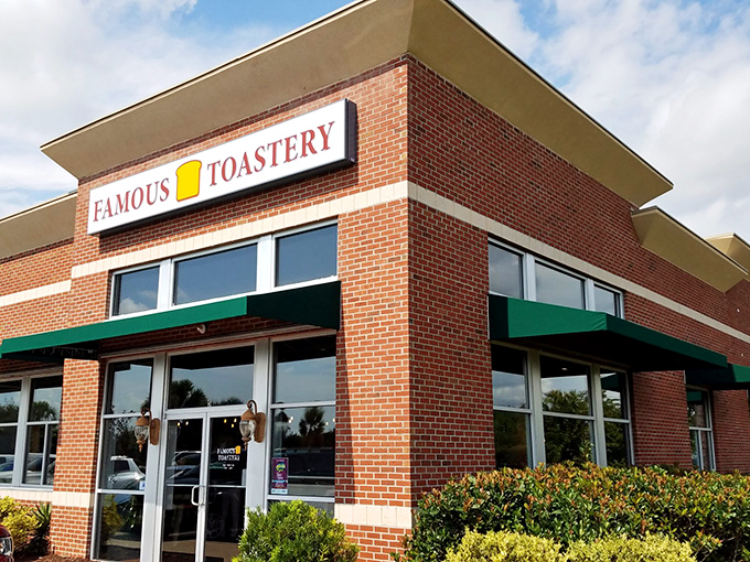 The brick facade of Famous Toastery stands like a breakfast beacon in Carolina Forest, its green awnings practically whispering "come get some eggs."