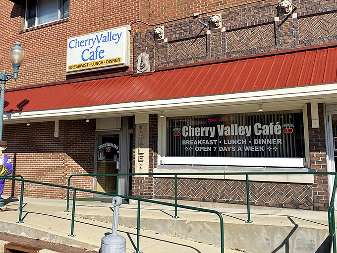 The brick facade and burgundy awning of Cherry Valley Cafe stands as a beacon of breakfast hope on Main Street, promising comfort food and conversation inside.