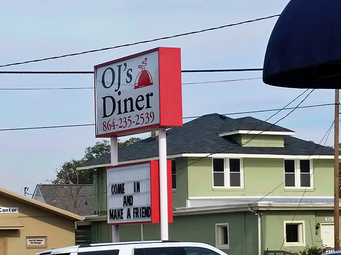 The unassuming brick exterior with that signature blue awning is like a secret handshake among Greenville locals who know where real Southern cooking lives.