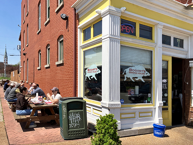 The bright yellow corner building beckons like a barbecue lighthouse in Soulard. Those picnic tables aren't just seating—they're front-row tickets to flavor town.