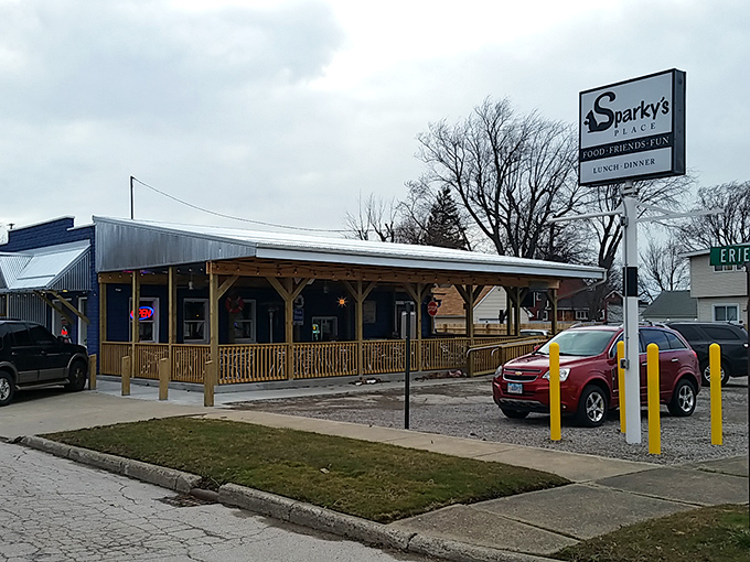 Rustic charm meets lakeside comfort at Sparky's Place, where that wooden porch practically whispers, "Come on in, the food's waiting!"