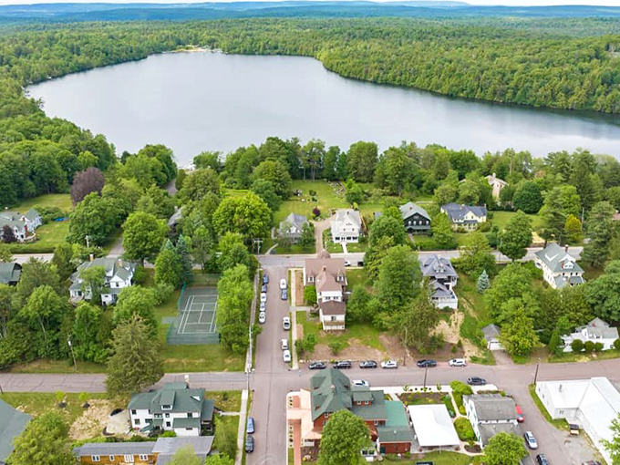 Downtown Eagles Mere showcases its timeless charm with a vintage clock standing sentinel among blooming rhododendrons &ndash; small-town Americana at its picture-perfect best.