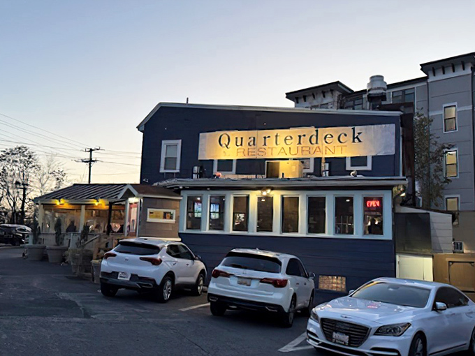 The navy blue exterior of Quarterdeck glows at dusk, a beacon for crab lovers hiding in plain sight along Arlington's streets.