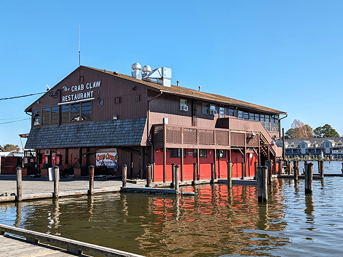 The Crab Claw stands proudly over the water like a sentinel of seafood, its weathered wooden frame promising maritime delights within those red-trimmed walls.