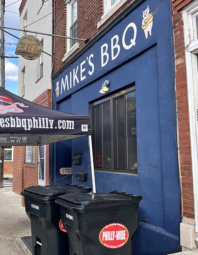 The blue storefront with cartoon pigs holding sandwiches says it all: serious barbecue served with a side of whimsy in South Philly.