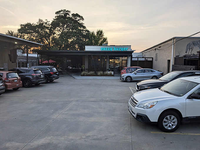The teal sign glows like a beacon at dusk, promising burger nirvana in an unassuming strip mall setting.