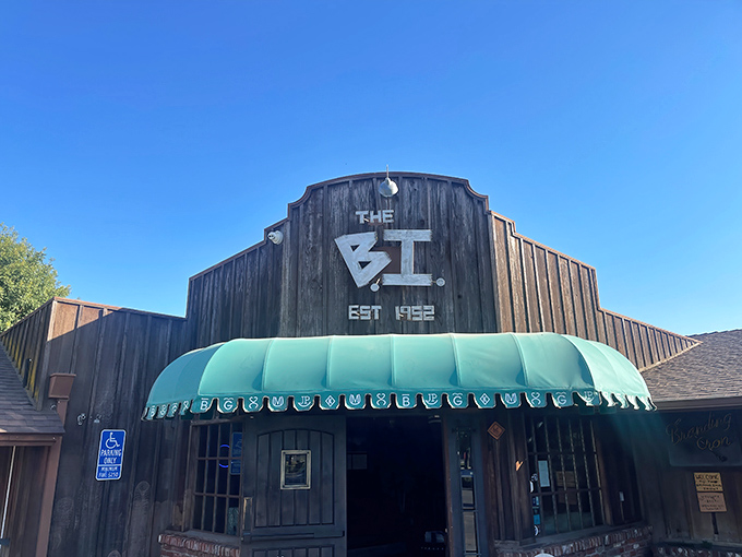 The iconic wooden facade of "The B.I." stands proudly against the California sky, its turquoise awning beckoning hungry travelers like a culinary lighthouse.