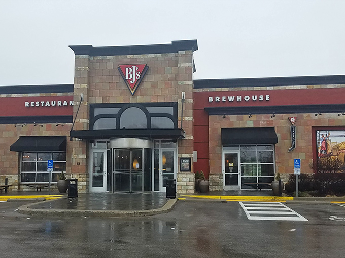 The stone and brick exterior of BJ's glows like a beacon at dusk, promising comfort and culinary adventure to weary Polaris shoppers.
