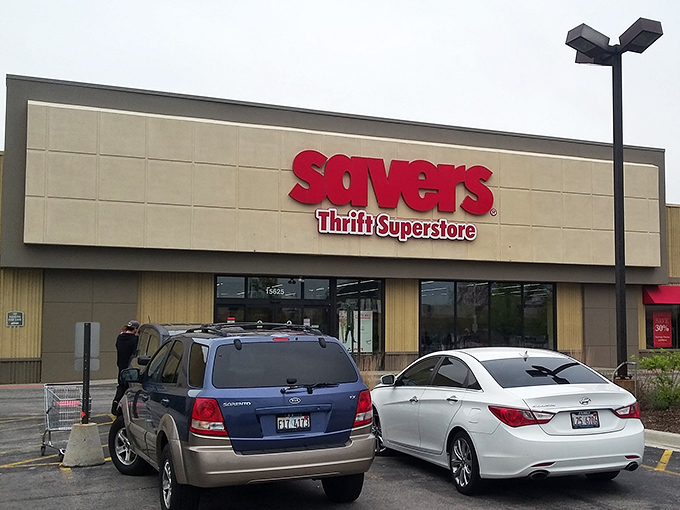 The bold red Savers sign beckons like a lighthouse for bargain hunters navigating the sea of retail sameness.