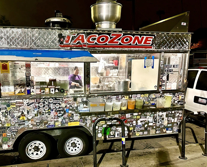 The silver chariot of late-night salvation, Taco Zone's sticker-adorned truck gleams under streetlights like a beacon to hungry night owls across Echo Park.