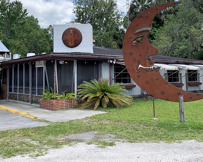 The unassuming exterior of The Yearling, complete with vintage Coca-Cola sign and that whimsical metal moon sculpture, promises authentic Florida without the tourist brochure gloss.