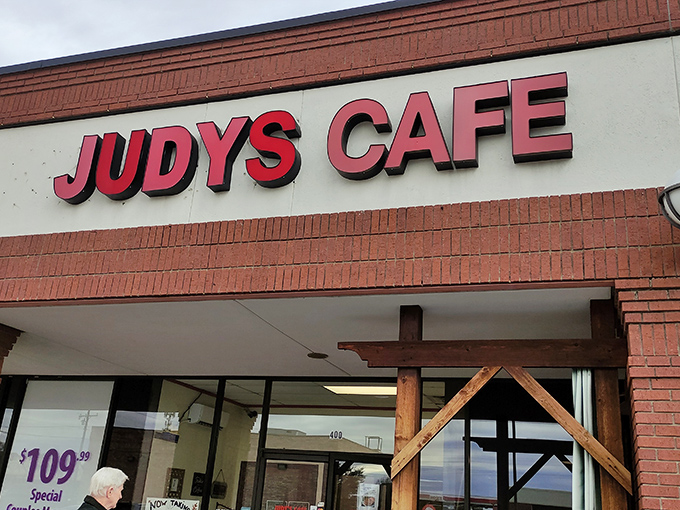 The red lettering of Judy's Cafe against brick promises what every great Texas breakfast spot should: no pretension, just honest-to-goodness satisfaction waiting inside.