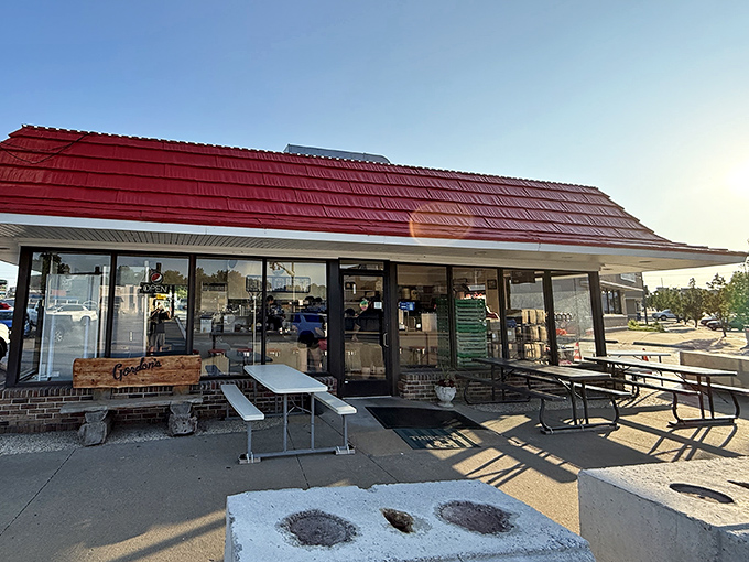 The iconic red roof of Gordon's Stop Light Drive-In stands as a beacon of burger hope along the Crystal City roadside since 1948.