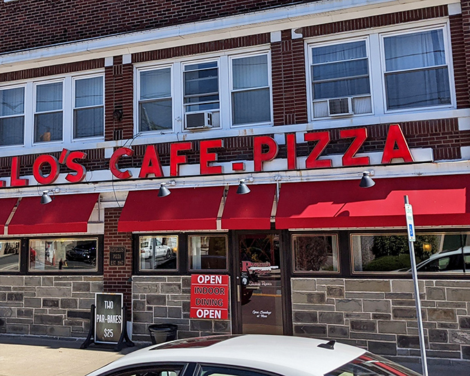 The iconic red awnings and vintage signage of Revello's stand as a beacon to pizza pilgrims seeking Old Forge's rectangular revelation.