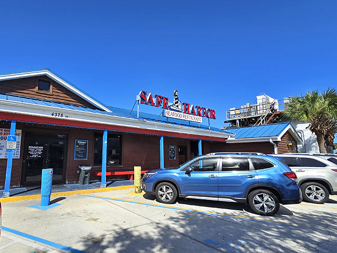 The bright blue roof of Safe Harbor beckons like a maritime lighthouse, promising seafood treasures within. Florida's coastal charm personified in weathered wood and nautical signage.