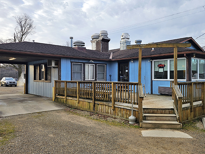 The blue exterior of Wedgewing Family Restaurant stands as a beacon of comfort food promise, complete with a wooden deck that practically whispers "come on in, stranger."
