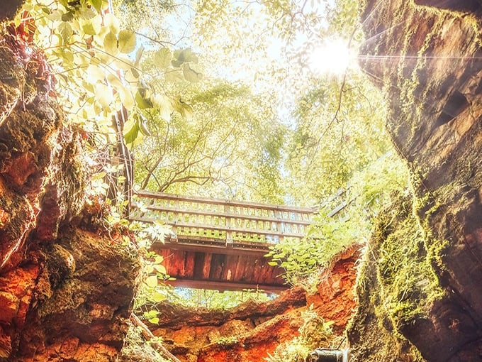 Explorers glide across the emerald waters of Devil's Well, their kayaks illuminated like alien spacecraft beneath the cathedral-like cavern ceiling.