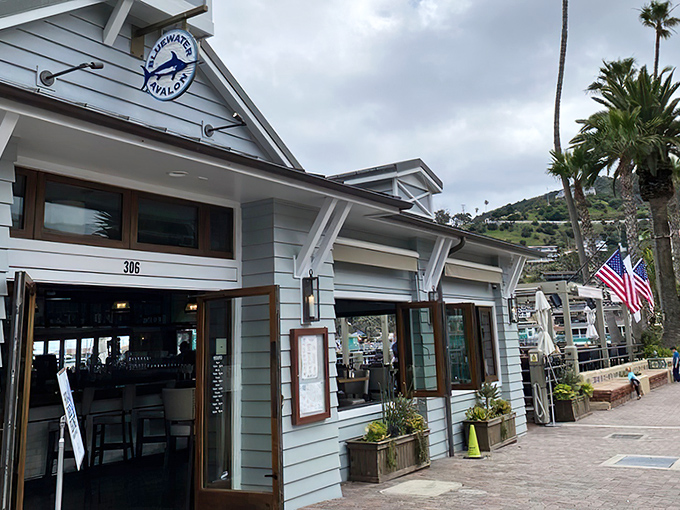 The crisp white exterior of Bluewater Avalon beckons like a maritime mirage, promising seafood treasures within its nautical-themed walls.