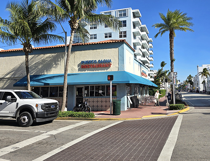 The iconic blue exterior of Puerto Sagua stands like a culinary lighthouse on Collins Avenue, beckoning hungry travelers with promises of Cuban delights.