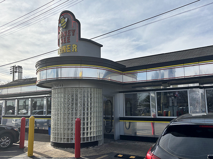 The iconic Honey Bee Diner exterior gleams like a beacon of breakfast hope on Ritchie Highway, its cheerful bee mascot promising sweet satisfaction ahead.