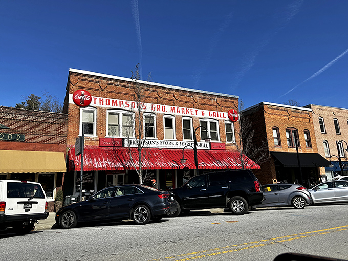 The iconic red awning of Thompson's Store & Ward's Grill beckons hungry travelers like a culinary lighthouse on Saluda's Main Street.