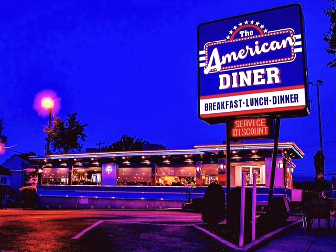 The American Diner glows like a neon-lit beacon against the twilight sky, promising comfort and calories in equal measure.