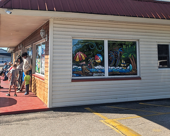 The beach-themed window art at this unassuming roadside gem promises Florida flavor, while the line of hungry patrons suggests breakfast treasures await inside.