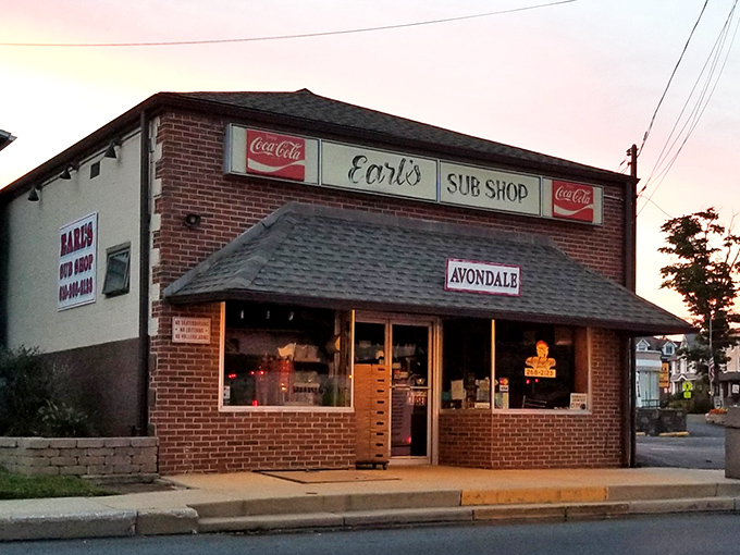 The brick fa&ccedil;ade of Earl's Sub Shop stands as a timeless monument to sandwich perfection, beckoning hungry travelers with its classic Coca-Cola signage and small-town charm.