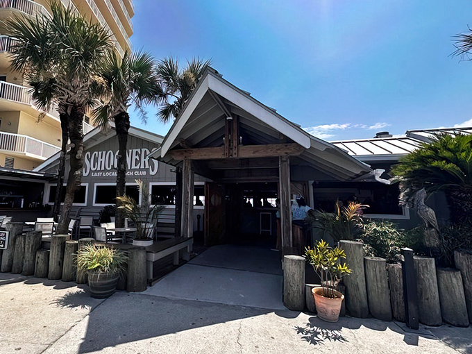 The ultimate beach bum's paradise! Schooners proudly declares itself the "Last Local Beach Club," with motorcycles parked out front like exclamation points to that statement.