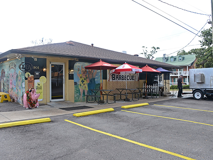 The unassuming yellow exterior of Hot Spot Barbecue, where those red umbrellas aren't just for show&mdash;they're beacons guiding hungry souls to barbecue nirvana.