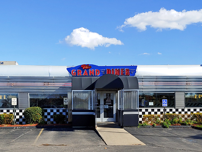 The classic stainless steel exterior gleams in the Michigan sunshine, promising comfort food treasures within. That neon sign? Pure roadside Americana.