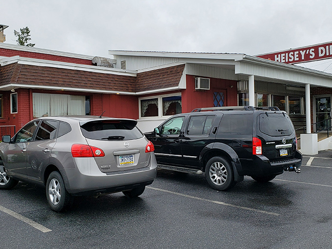 The unassuming red exterior of Heisey's Diner stands like a beacon of hope for hungry travelers. No pretension, just the promise of honest food inside.