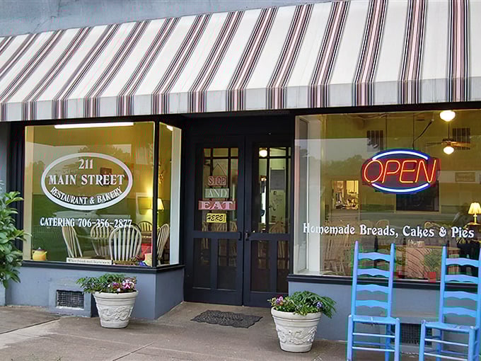 The welcoming storefront of 211 Main Street beckons with colorful flower pots and metal benches. Small-town charm doesn't get more inviting than this purple-trimmed slice of heaven.