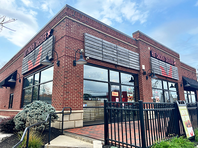 The brick fortress of flavor beckons from the street, promising Nashville heat with Midwestern hospitality inside those glass doors.