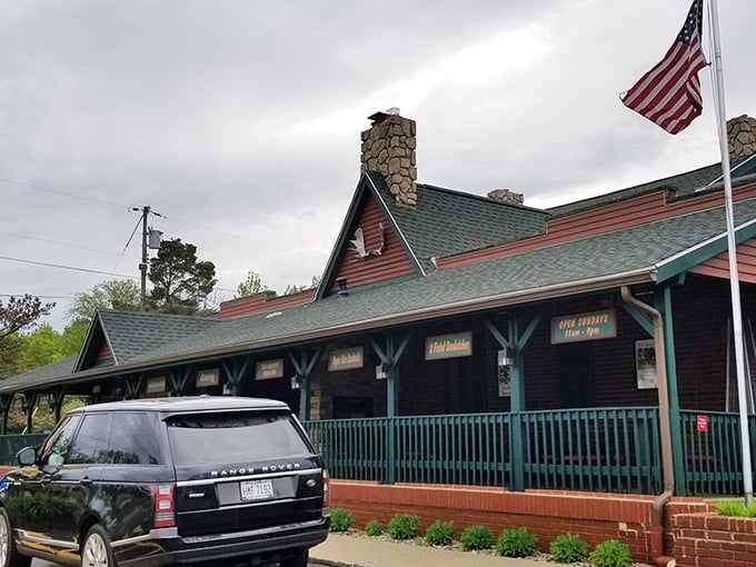 The rustic charm of Timber Lodge beckons from the roadside, its log cabin exterior and American flag promising a quintessentially Midwestern steakhouse experience.