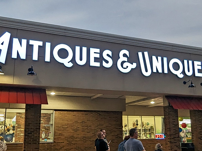 The iconic storefront of Antiques & Uniques beckons treasure hunters with its bold signage and welcoming red awnings. A time portal disguised as a retail establishment.