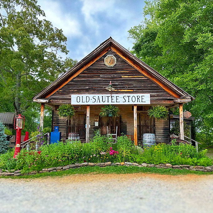 The Old Sautee Store stands proudly against the Georgia sky, its weathered wooden facade and inviting porch practically whispering tales from another century.