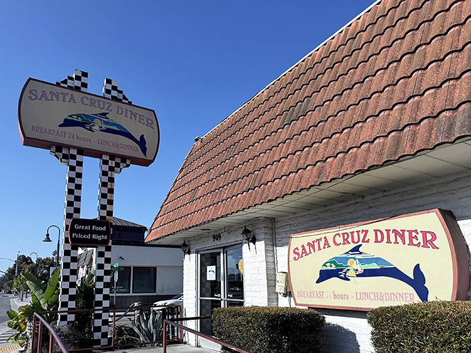 The iconic blue whale sign beckons hungry travelers like a lighthouse for the famished. Classic A-frame roof and checkered racing flags promise comfort food worth the pit stop.